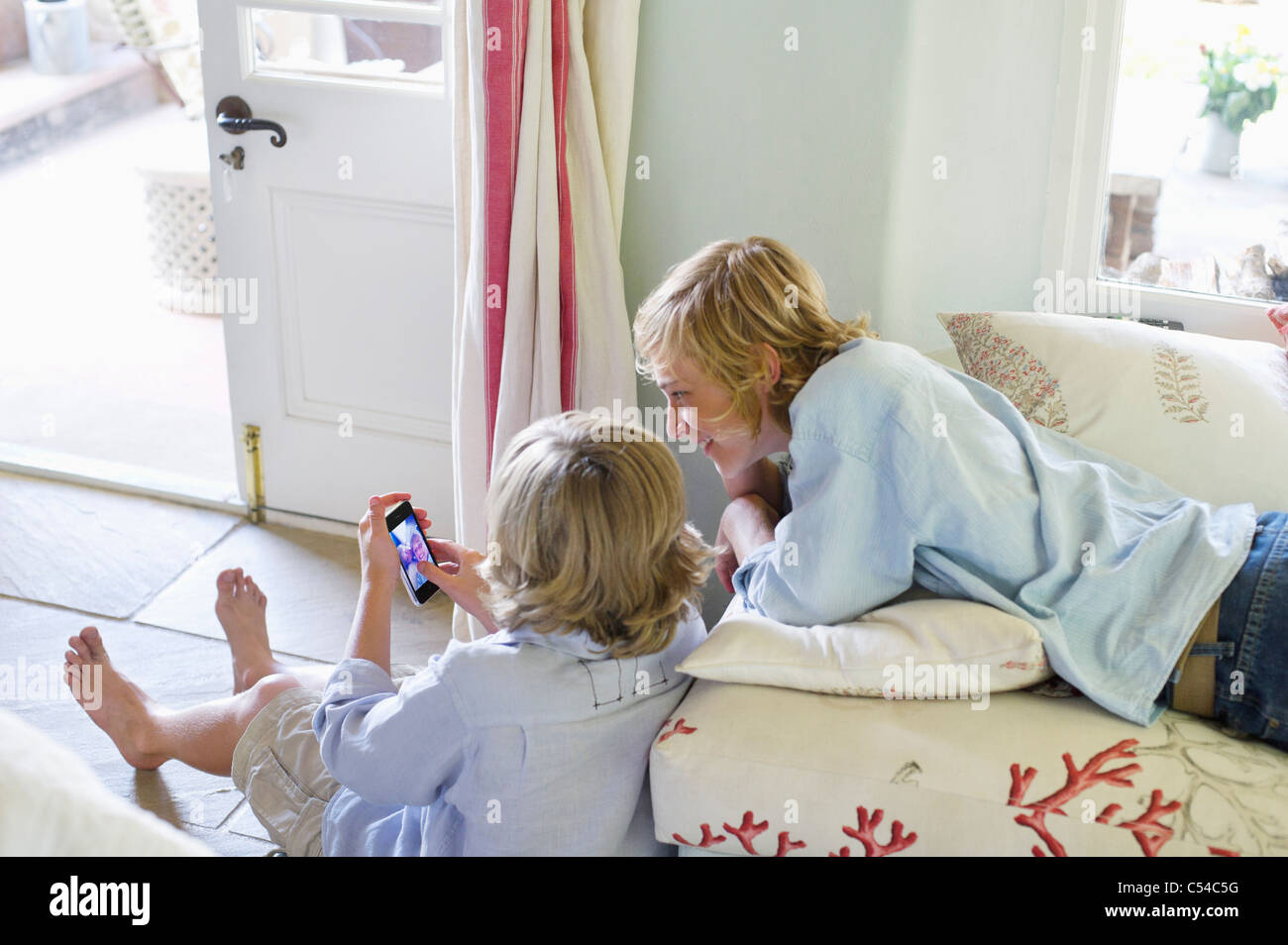 Children using mobile phone at house Stock Photo - Alamy