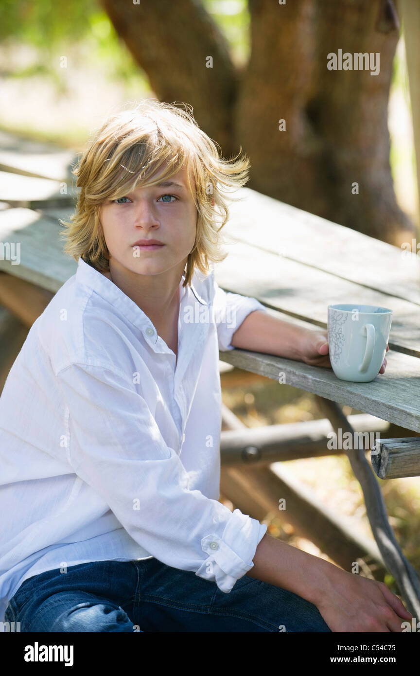 Contemplative little boy drinking tea outdoors Stock Photo - Alamy