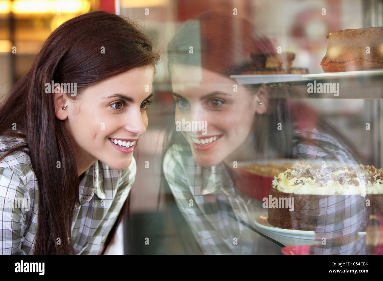 Woman looking at cakes in a bakery window Stock Photo - Alamy