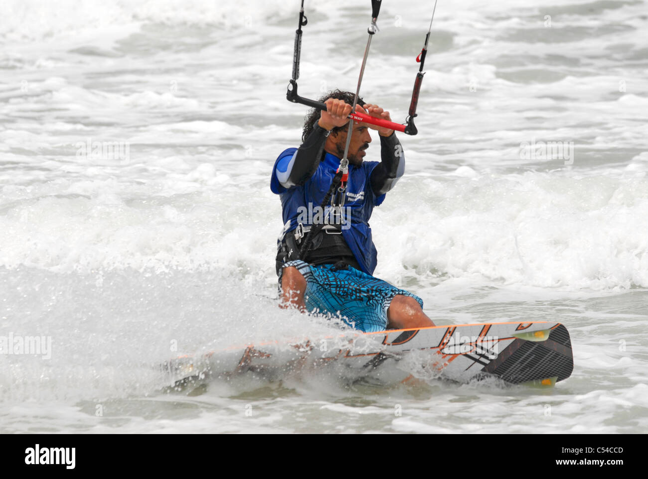 Kite surfer carving along shoreline Stock Photo - Alamy