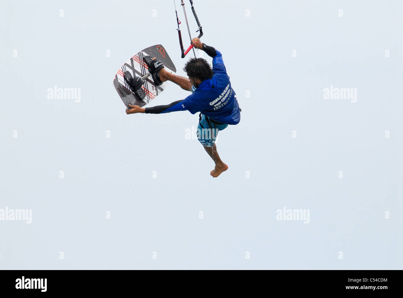 Kite surfer airborne with one foot of the board grabbing the tail Stock ...