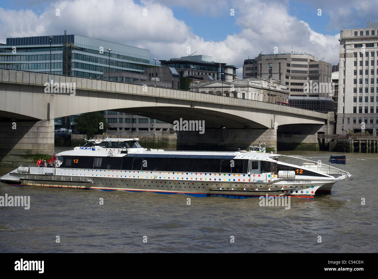 Passenger tourist boat sailing under London Bridge with City view ...