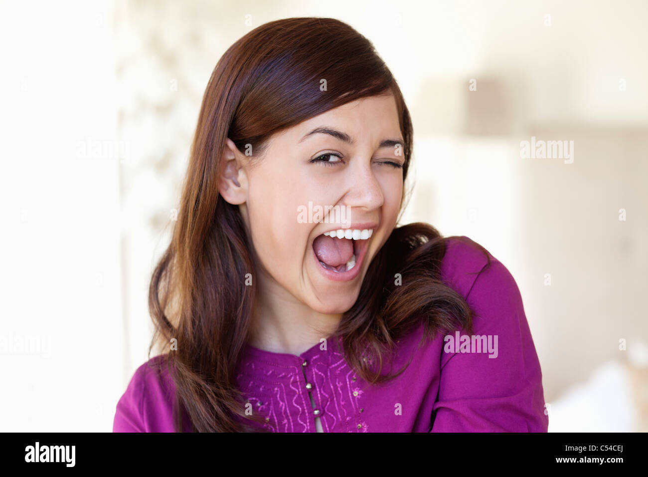 Portrait of a young woman winking Stock Photo - Alamy