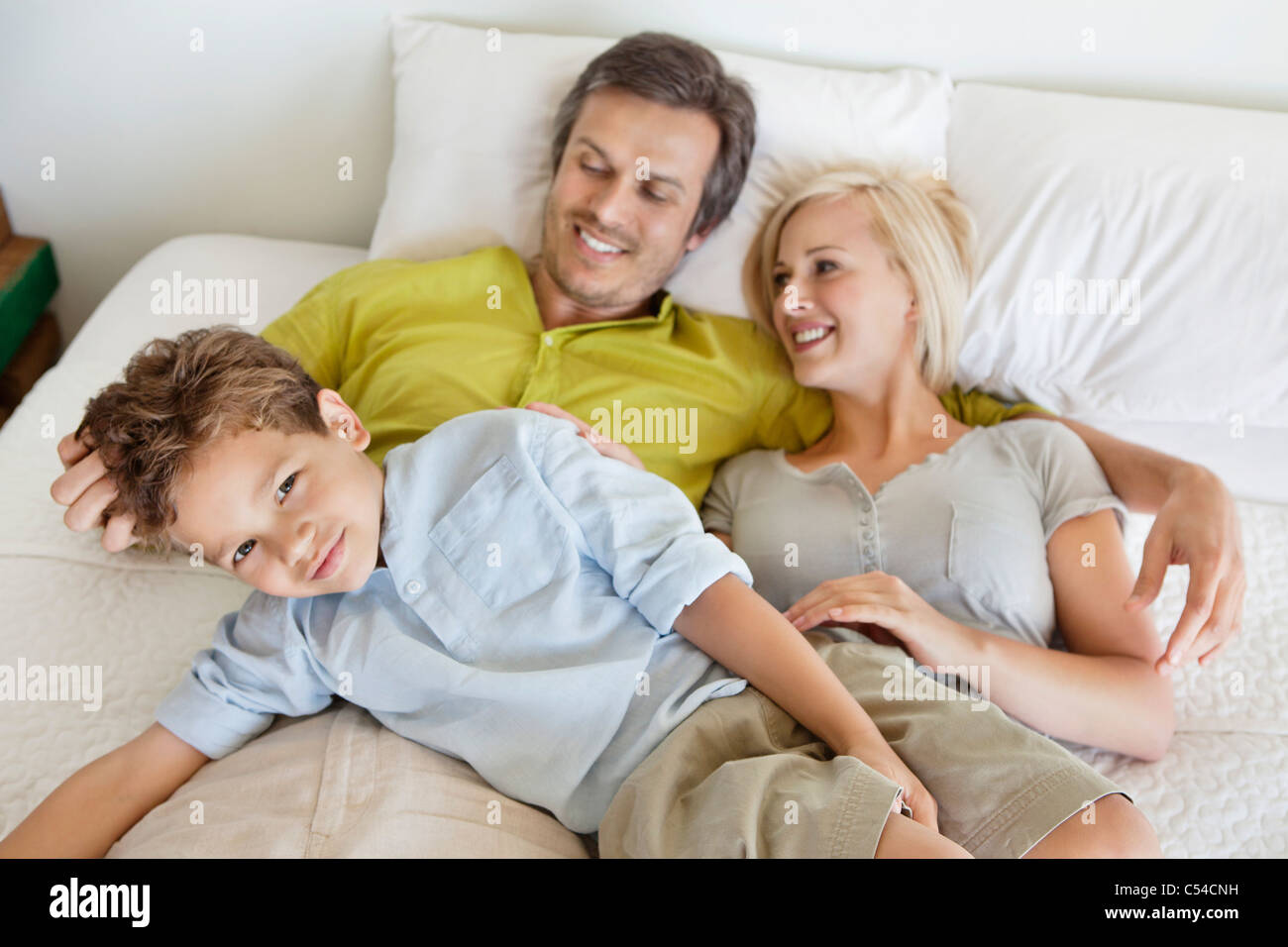 Parents with their son relaxing in bed Stock Photo - Alamy