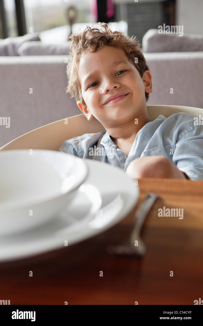 Smiling boy sitting table hi-res stock photography and images - Alamy