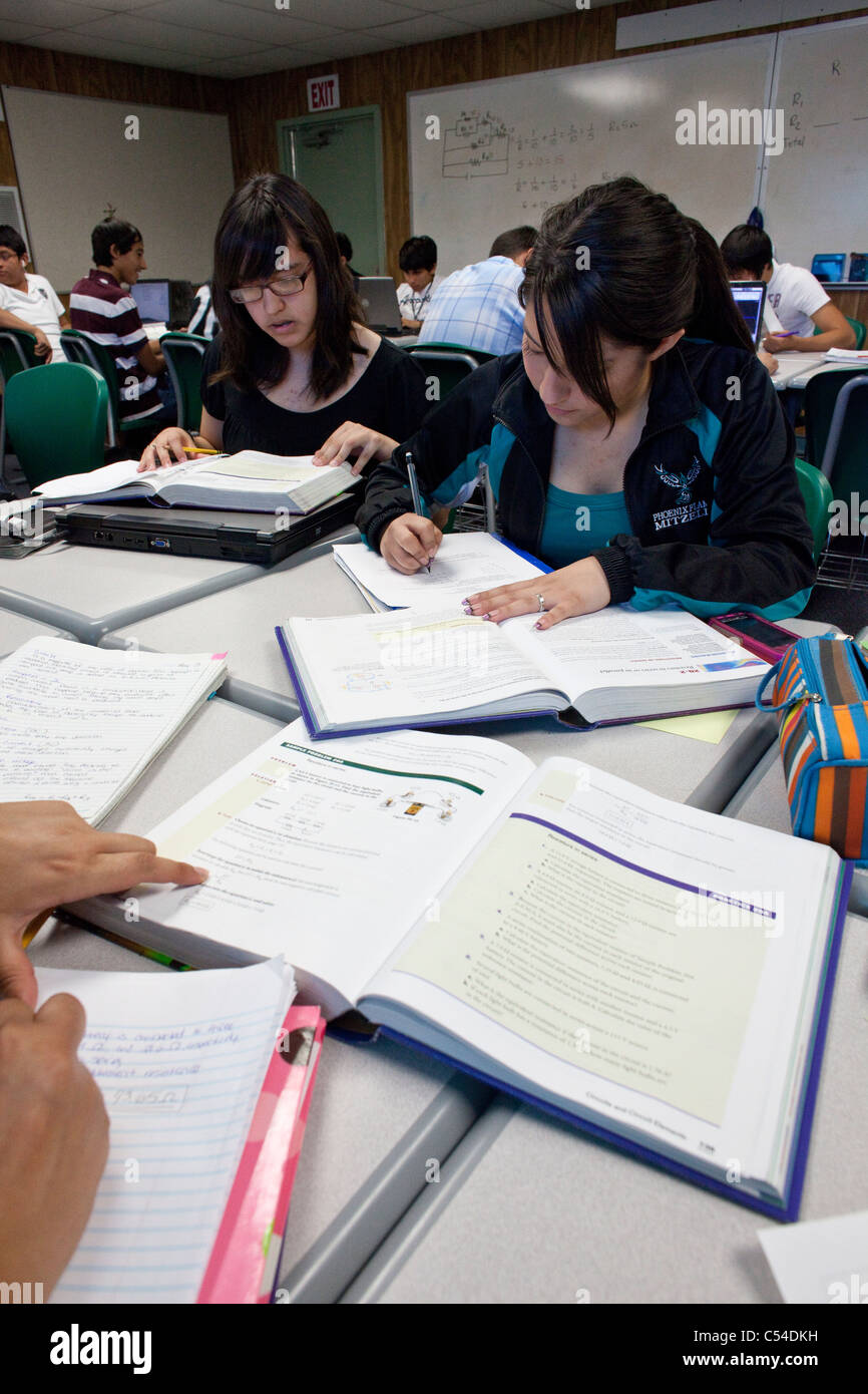 Students use textbooks on desks to write reports on notebooks inside ...