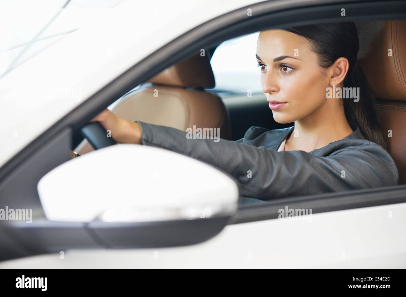 Beautiful young woman taking a test drive Stock Photo - Alamy