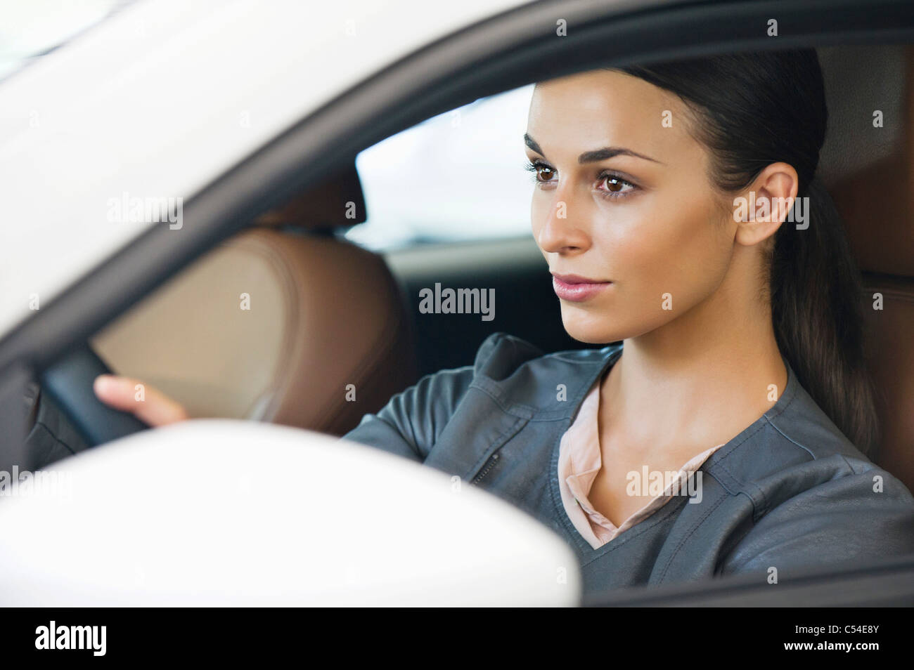 Beautiful young woman taking a test drive Stock Photo - Alamy