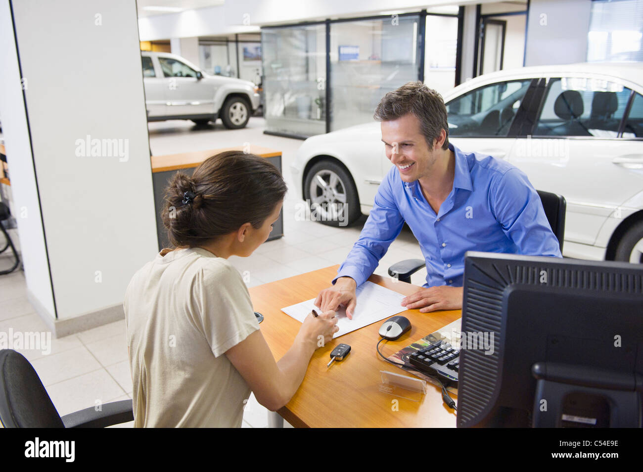 Mid adult man buying car in a showroom Stock Photo - Alamy