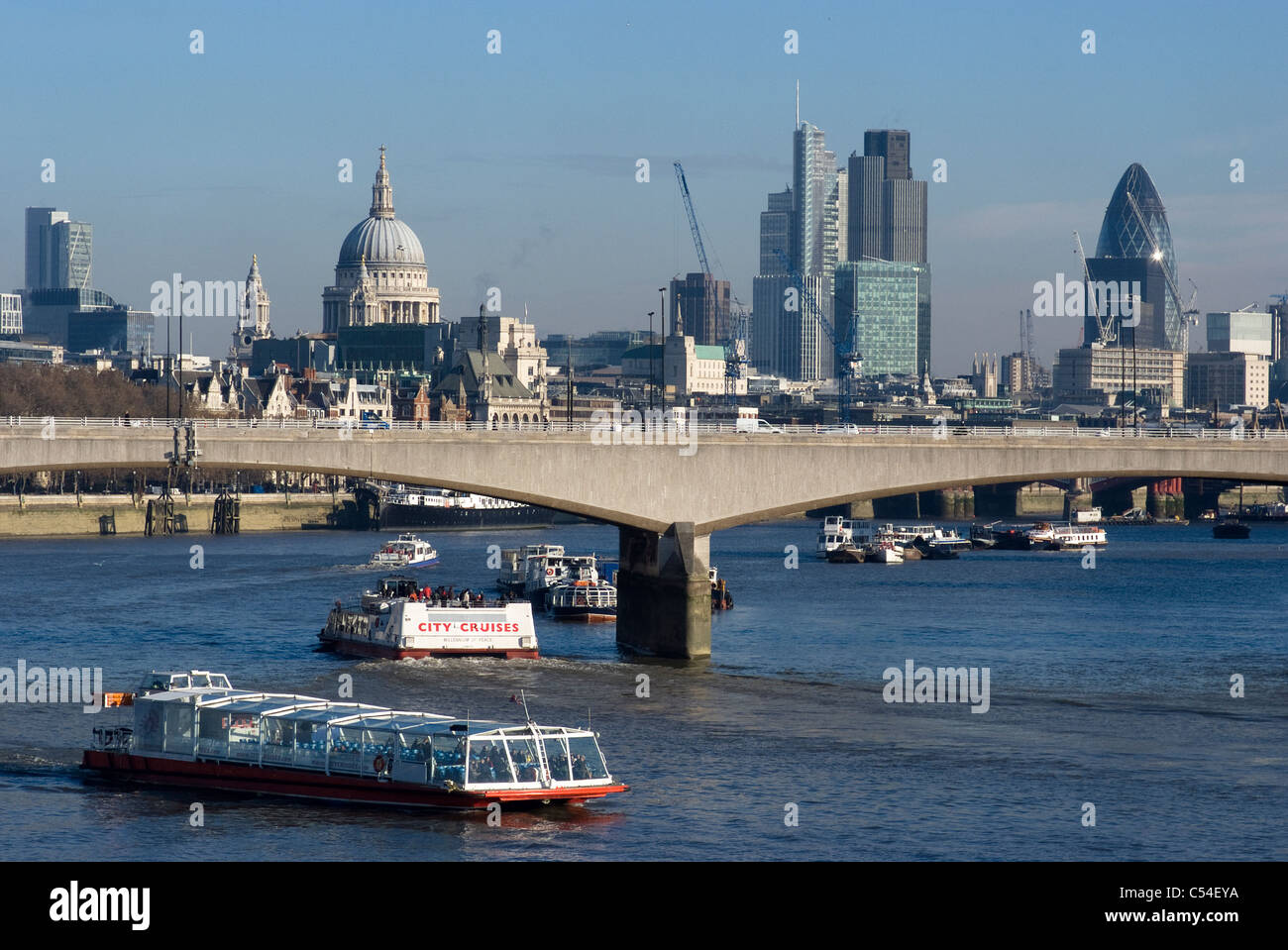 London Bridge over the River Thames with boats and the city skyline ...