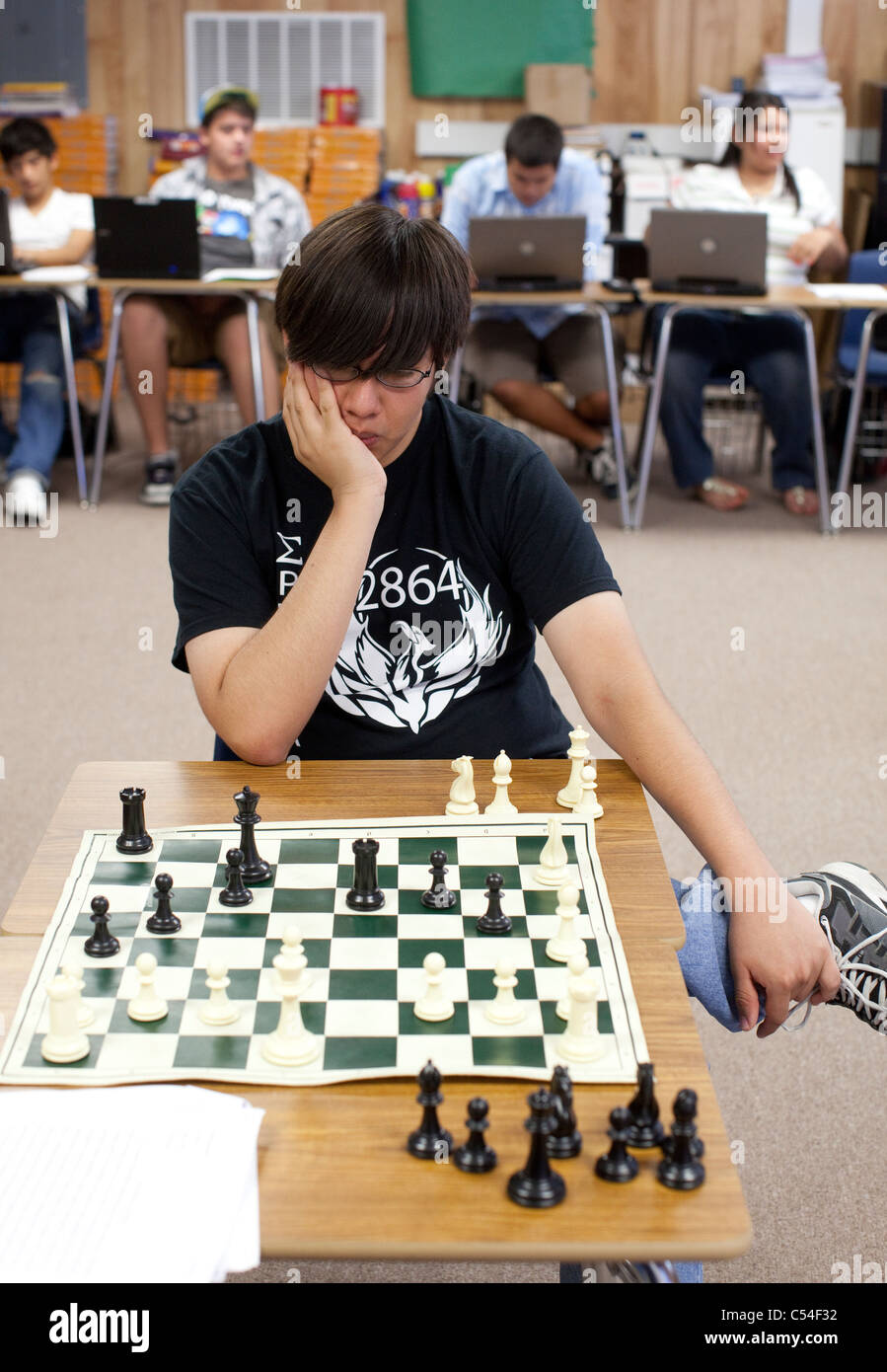 Teenage male students plays a game of chess in between classes at ...