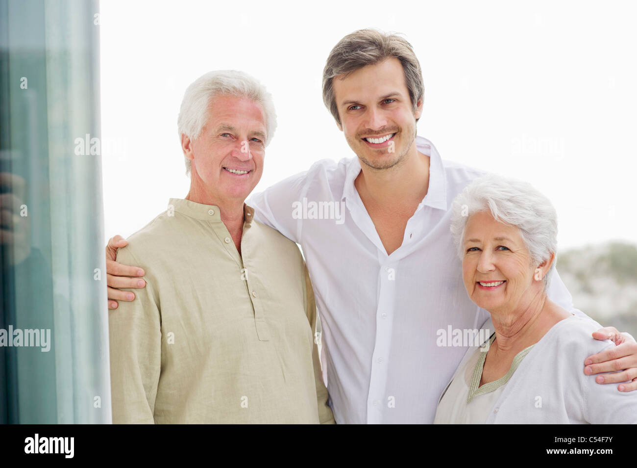 Portrait of a mid adult man standing with his arms around to his ...
