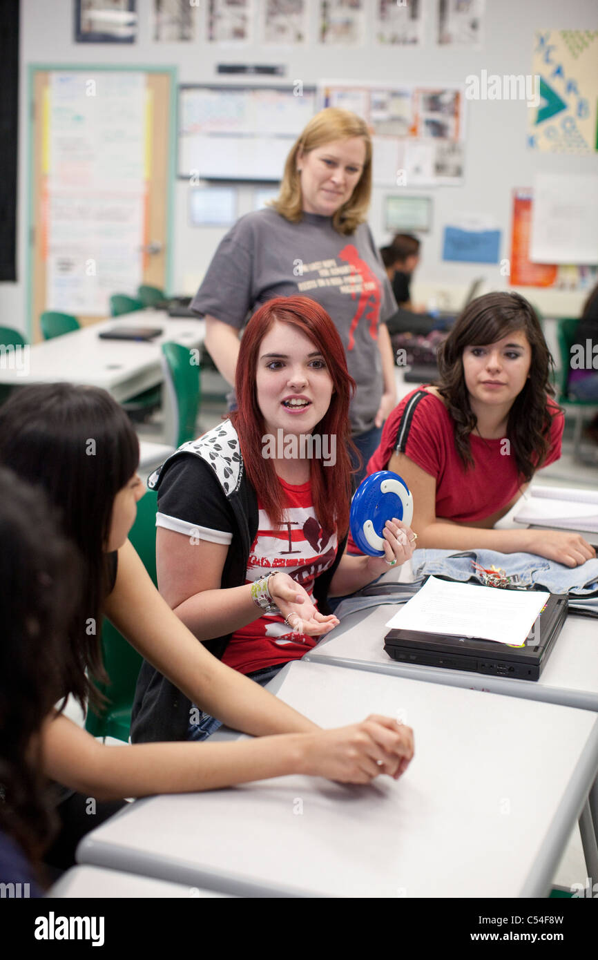 Female speaks to fellow high school students in classroom as female ...