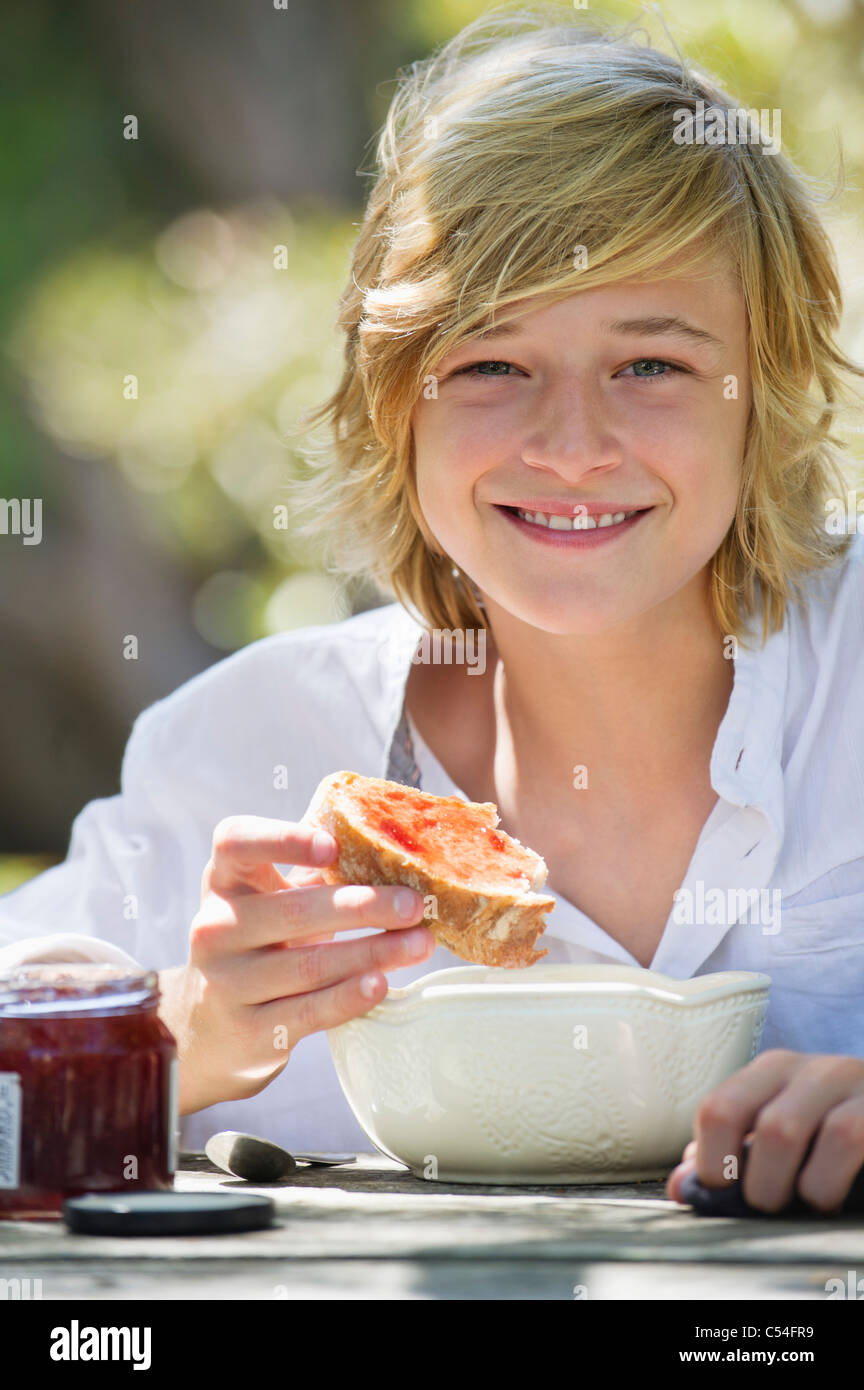 Portrait of a little boy eating bread with jam outdoors Stock Photo - Alamy