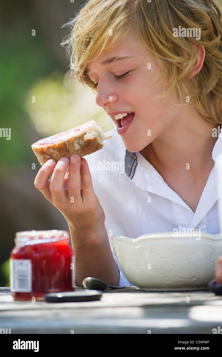 Little boy eating bread with jam outdoors Stock Photo - Alamy
