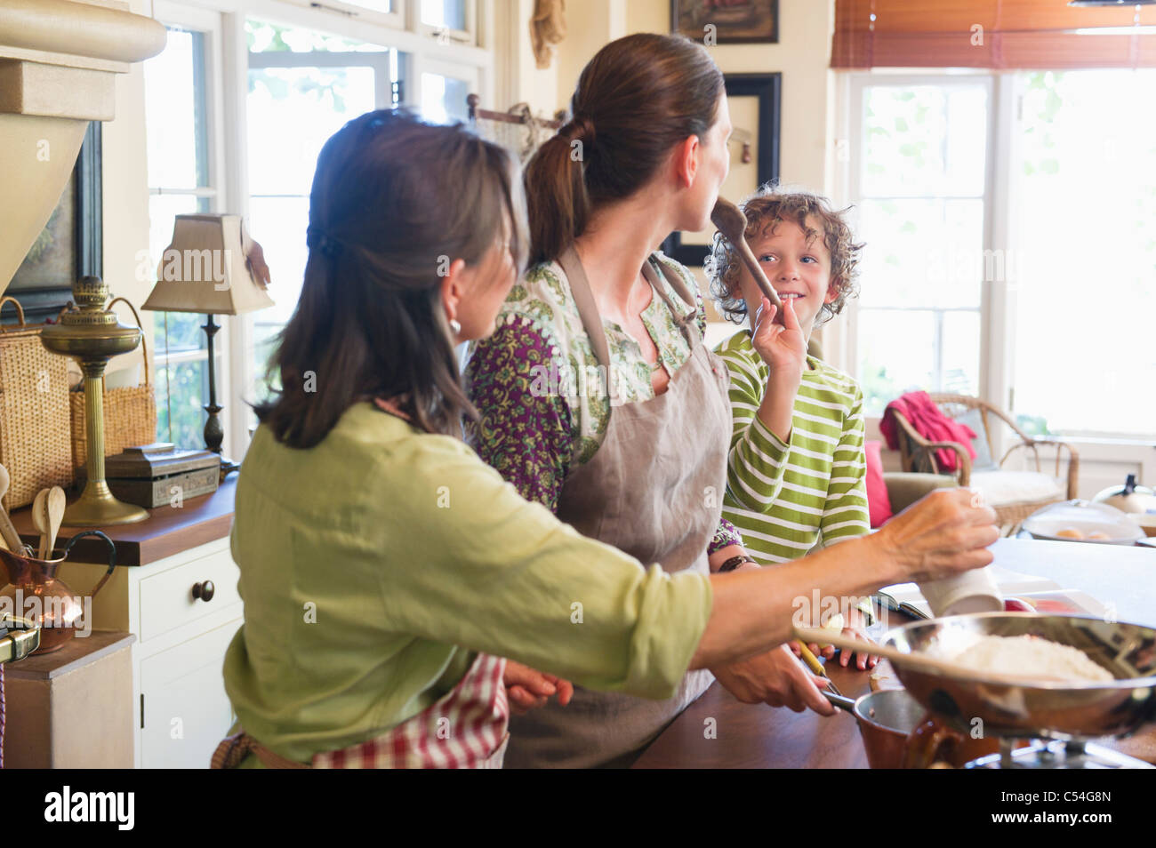 Multi generation family cooking food at kitchen Stock Photo - Alamy