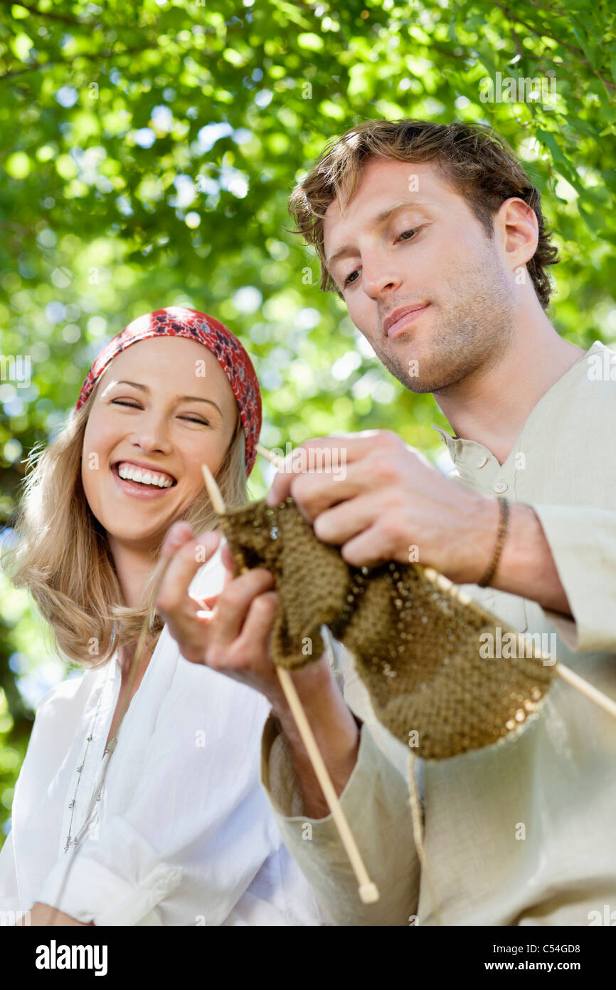 Young couple knitting together and smiling Stock Photo - Alamy