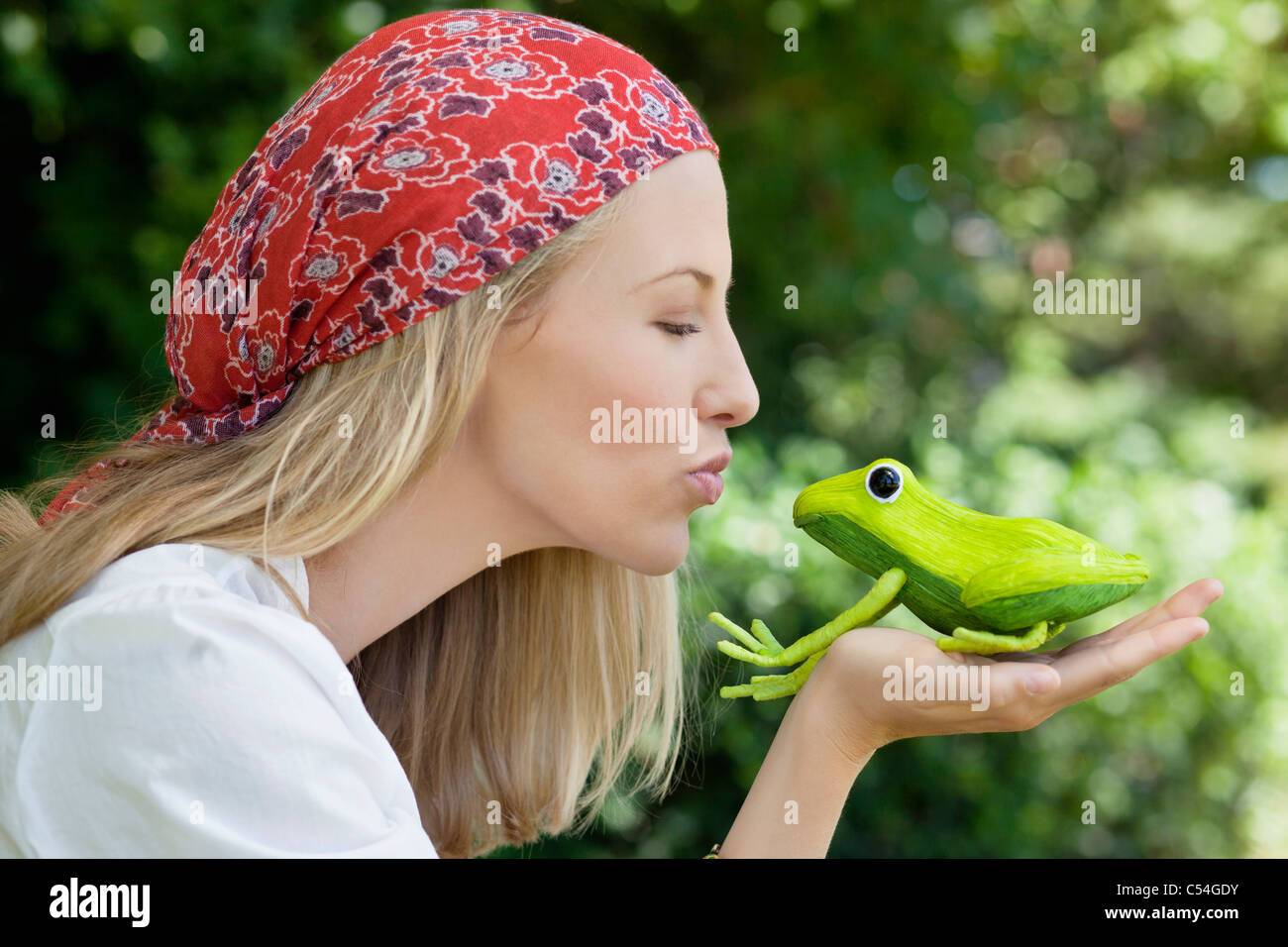 Young woman kissing a frog toy Stock Photo - Alamy