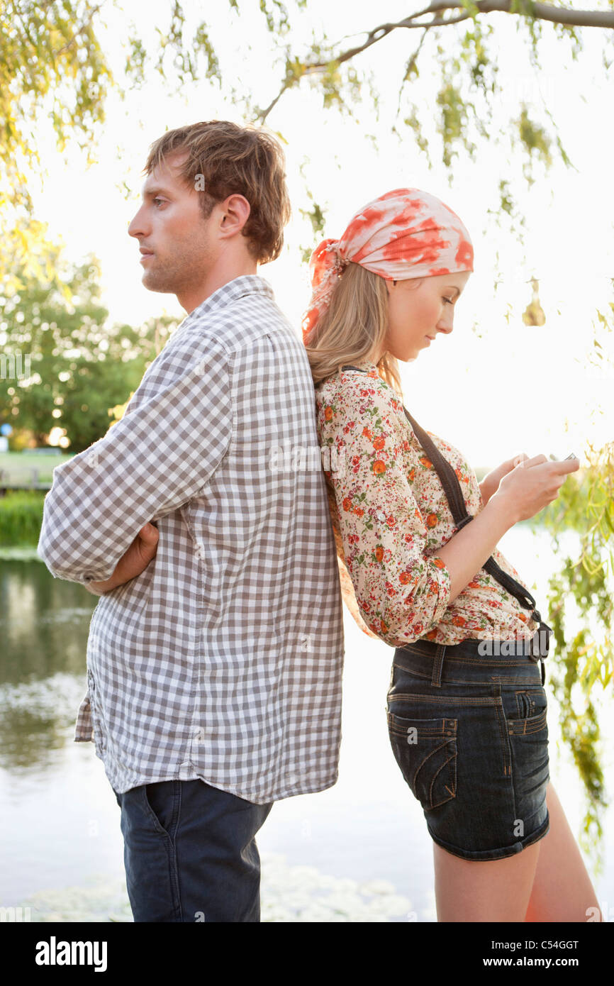 Side profile of a couple standing back to back Stock Photo - Alamy