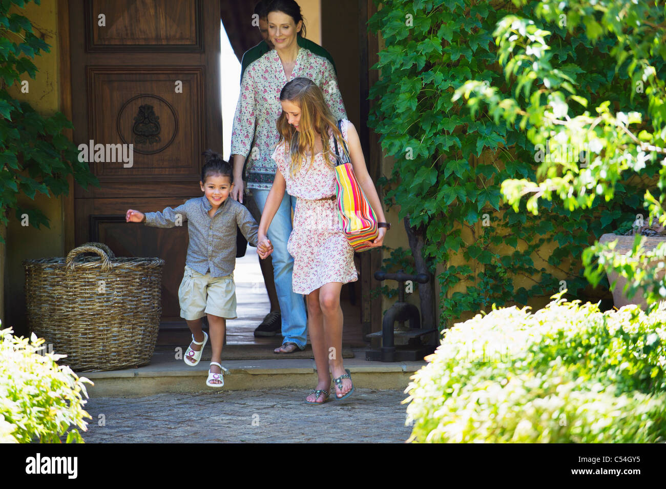 Happy family walking out of their house Stock Photo - Alamy