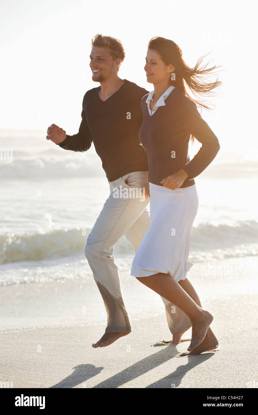 Couple running on the beach Stock Photo - Alamy