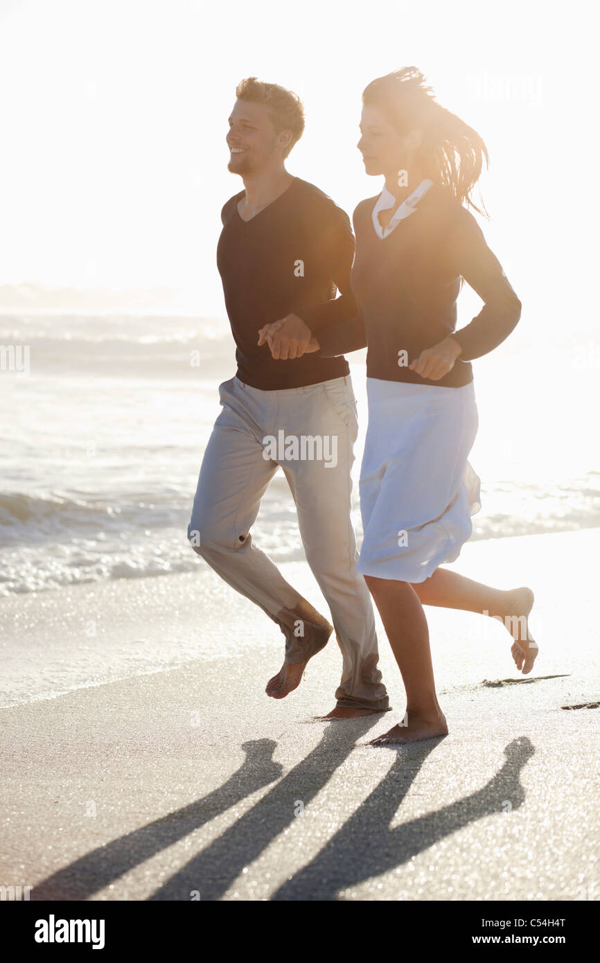 Couple running on the beach Stock Photo - Alamy
