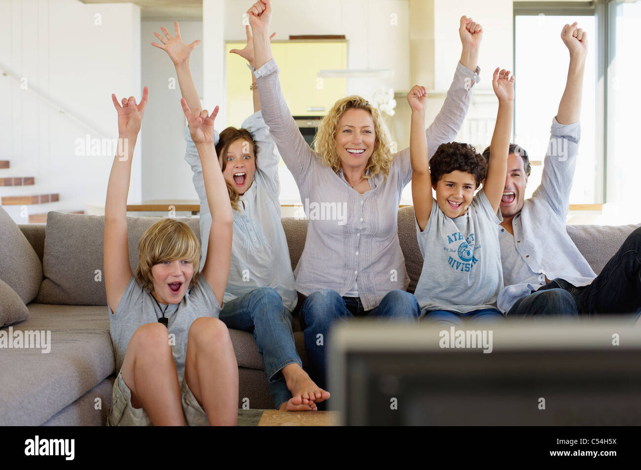 Family watching television set together at home Stock Photo - Alamy