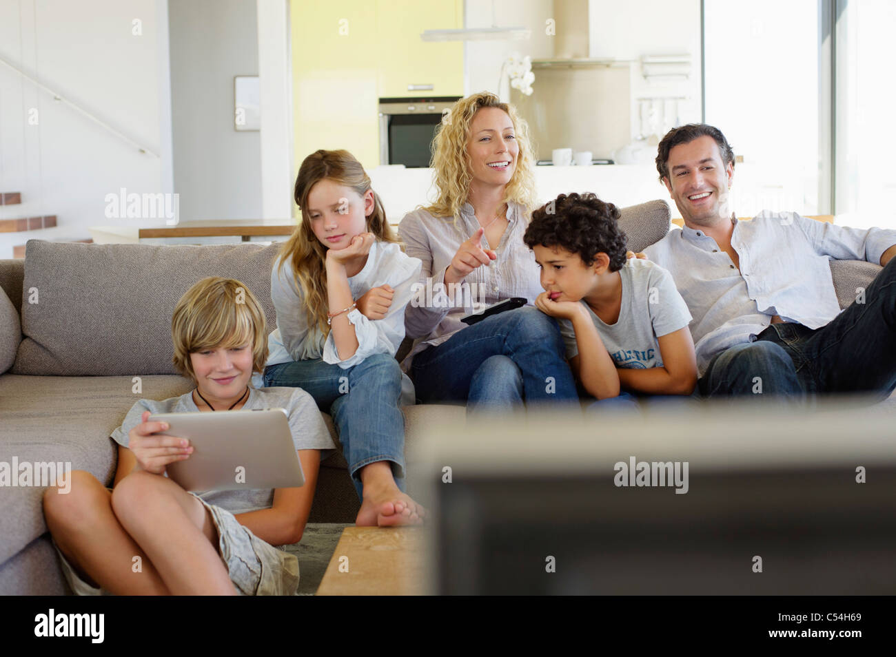 Family watching TV together at home Stock Photo - Alamy