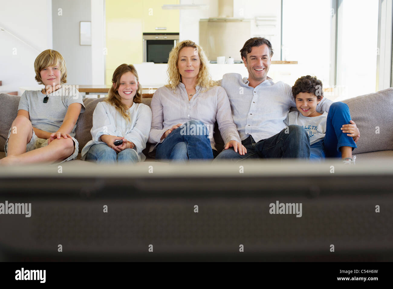 Family watching TV together at home Stock Photo - Alamy