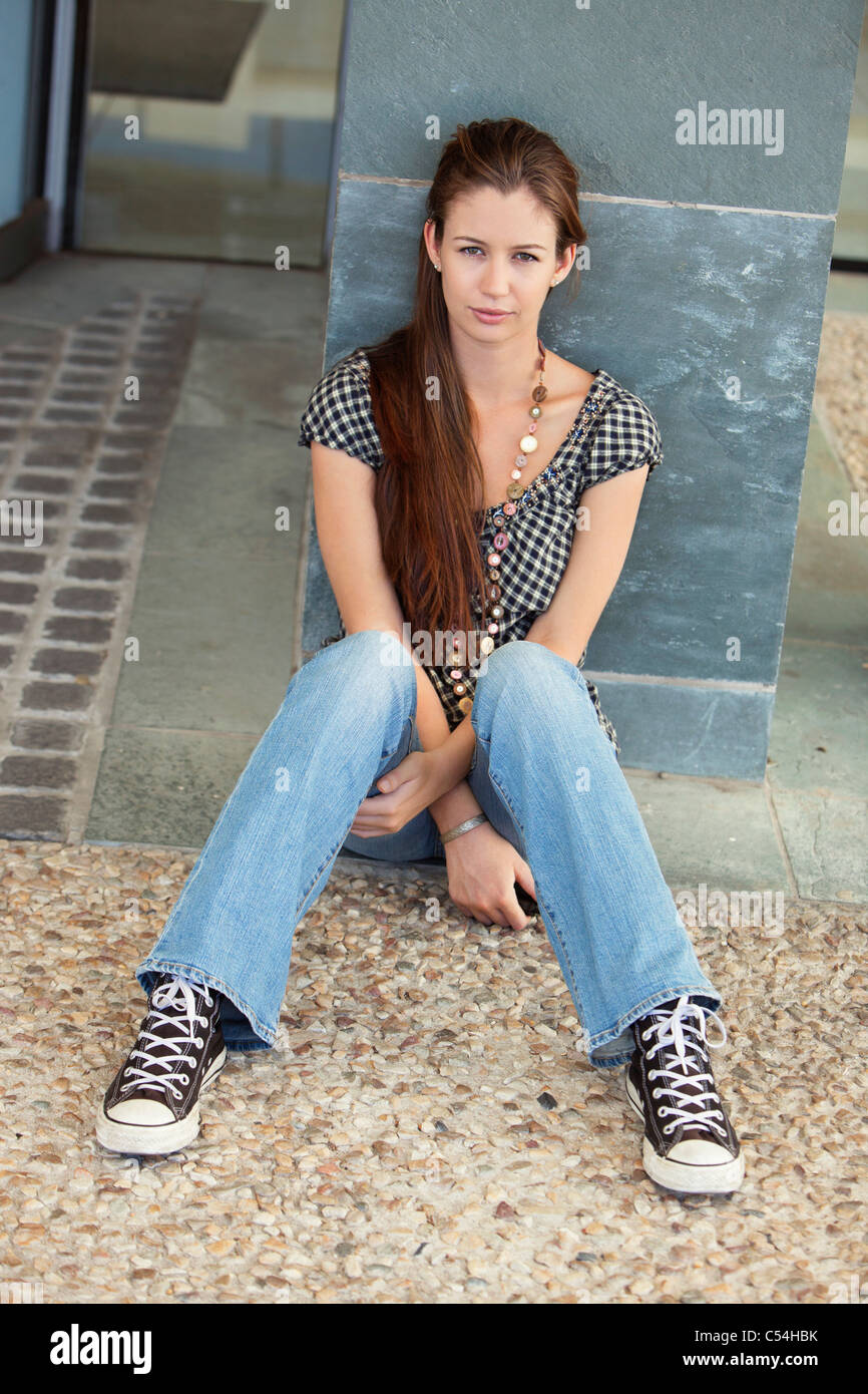 Portrait of a woman sitting on floor Stock Photo - Alamy