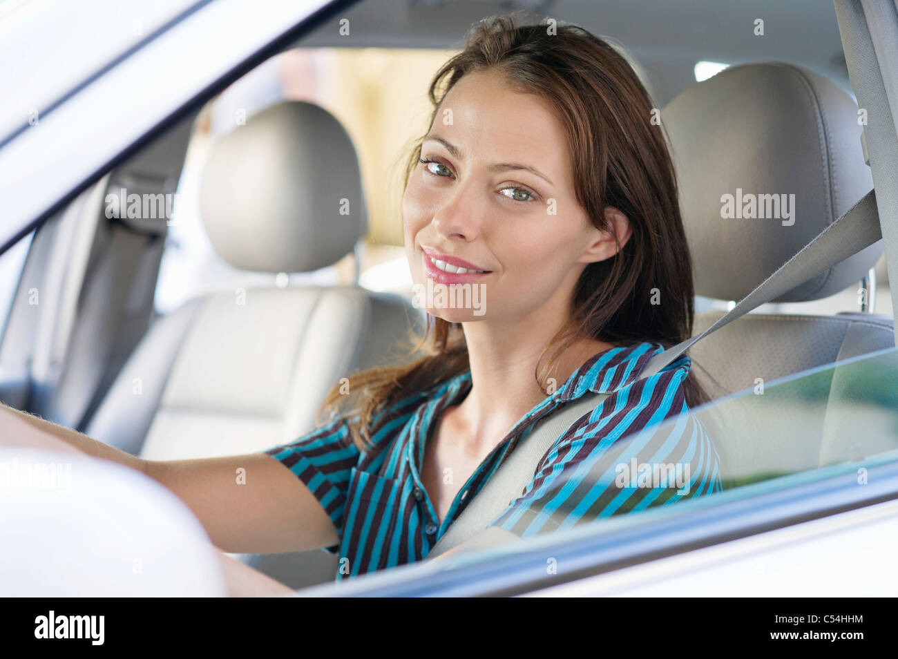 Portrait of a beautiful young woman sitting at driver's seat Stock ...