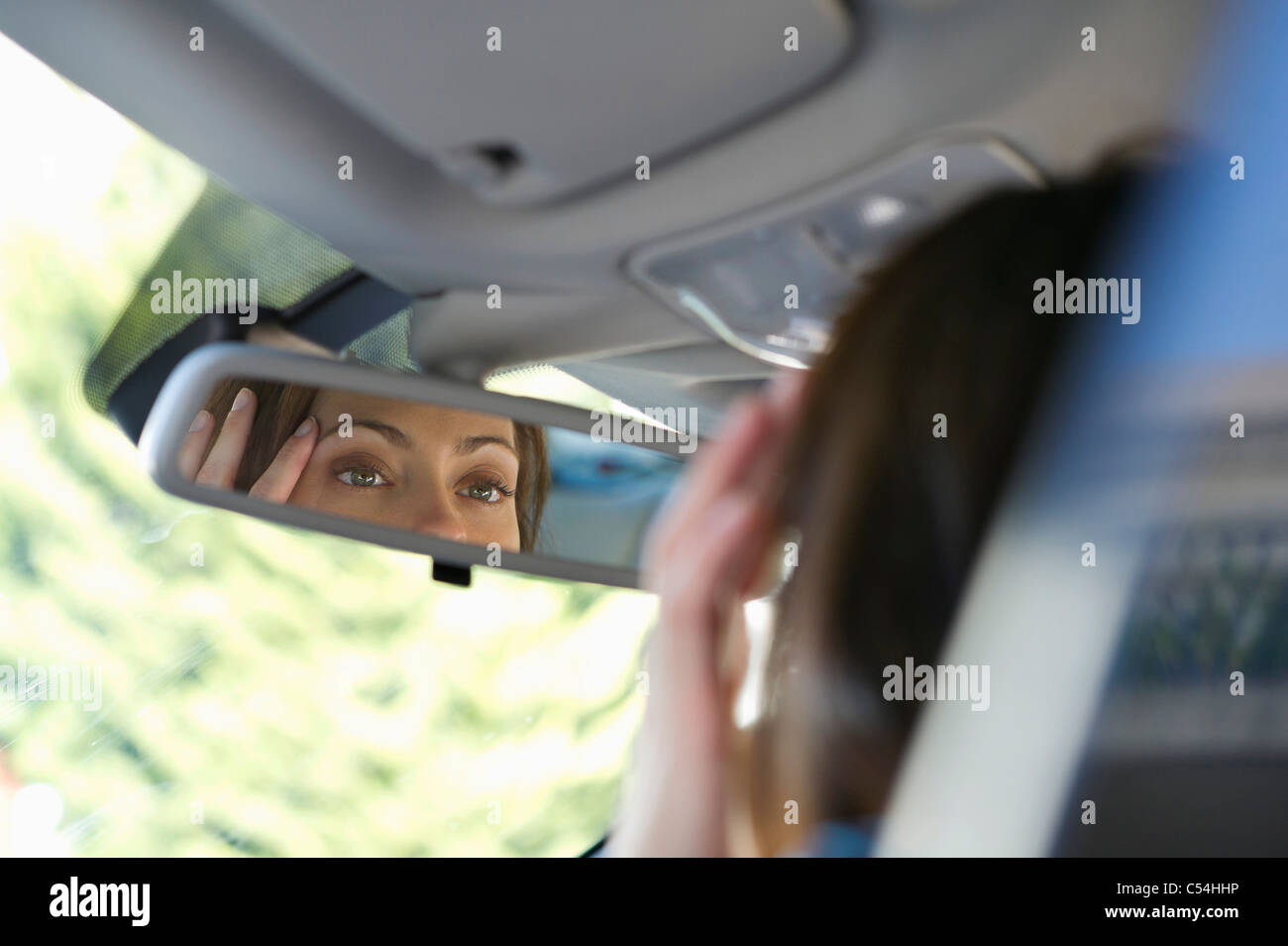 Reflection of a young woman eyes in rear-view mirror Stock Photo - Alamy