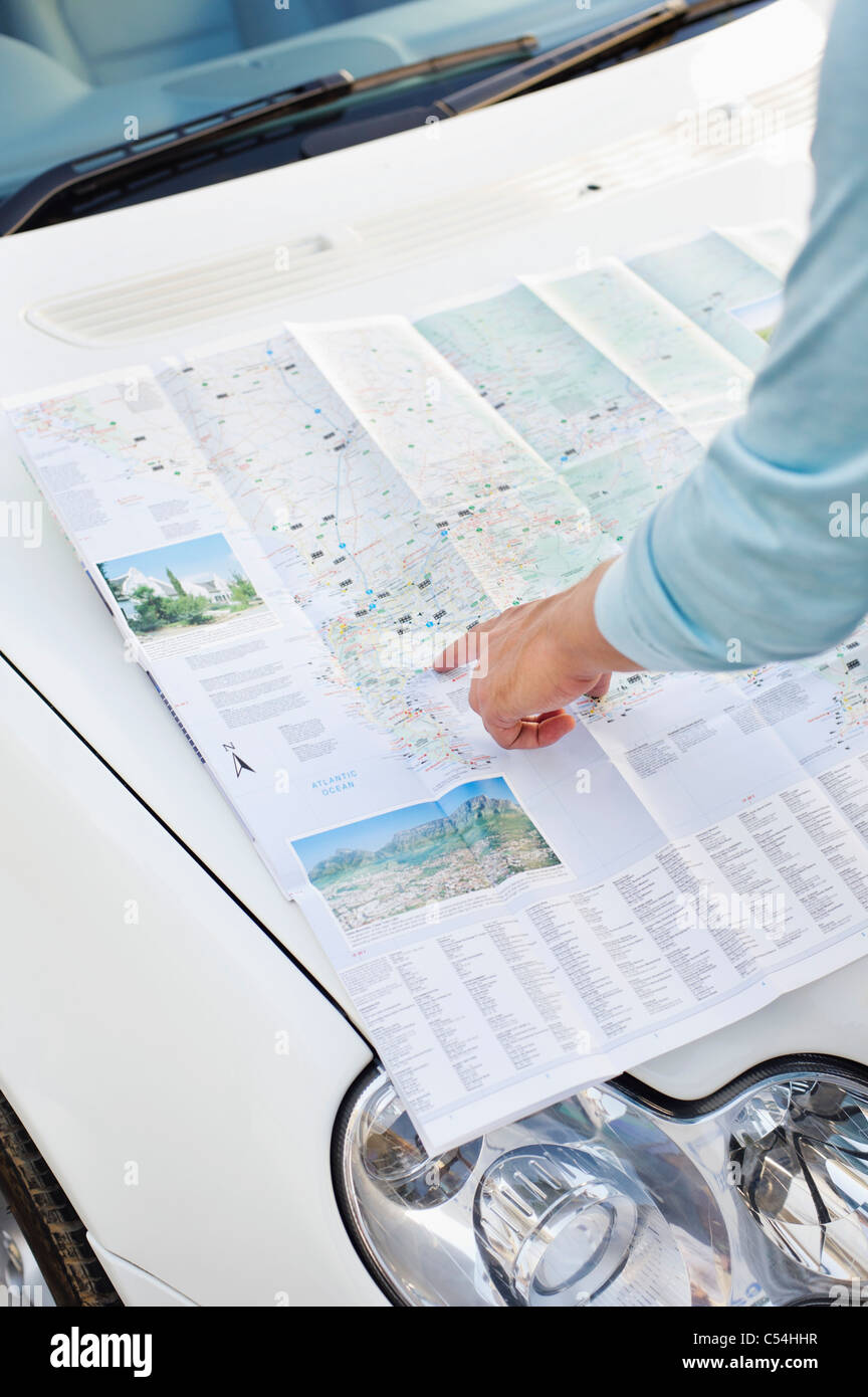 Man looking at a map on a car Stock Photo - Alamy