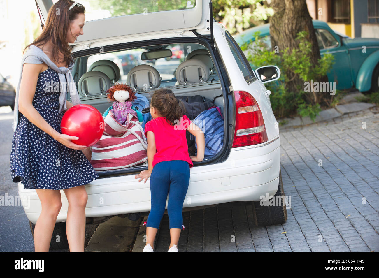 Little girl and her mother standing near a car Stock Photo - Alamy
