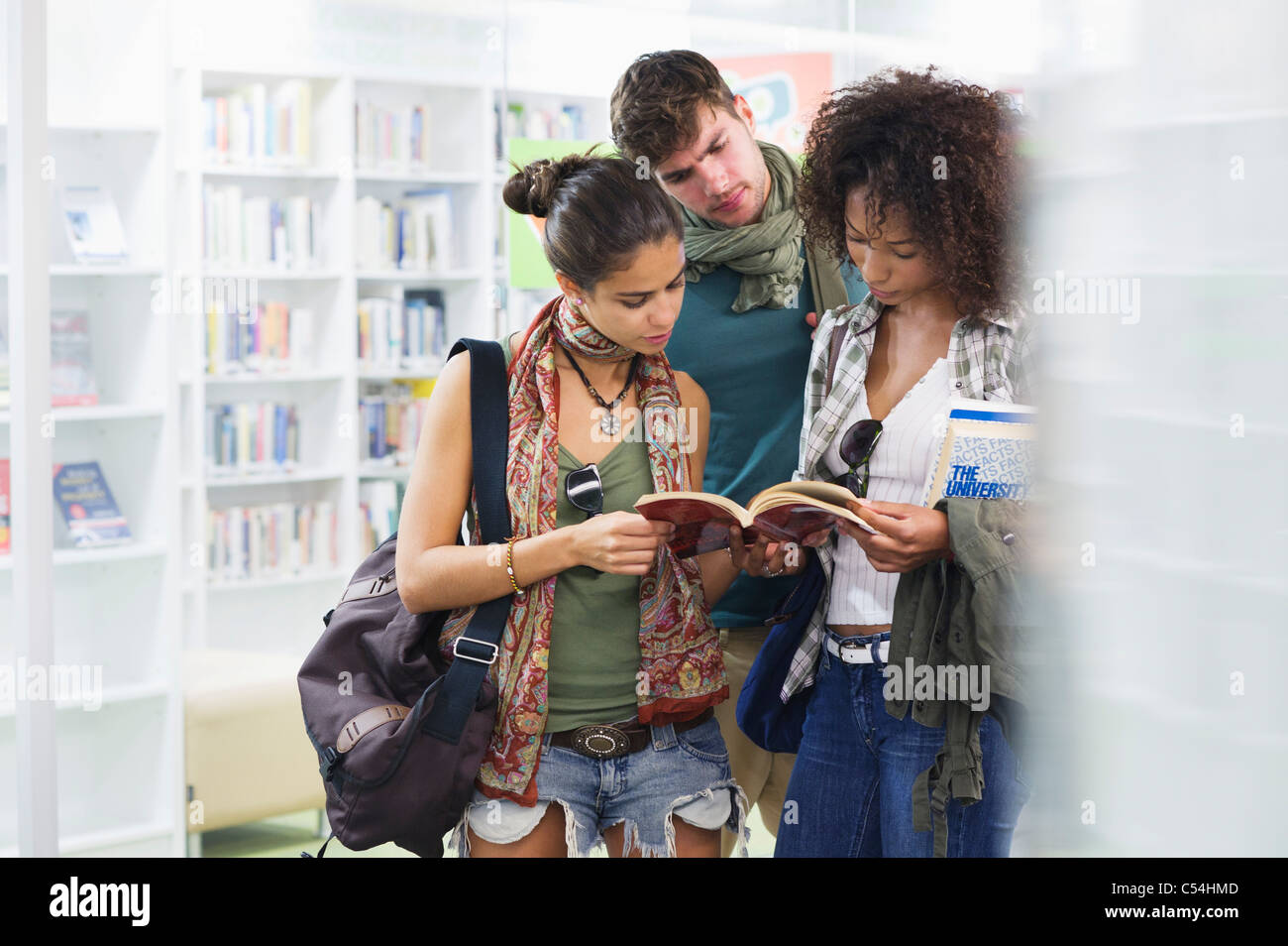 Three students studying in a library hi-res stock photography and ...