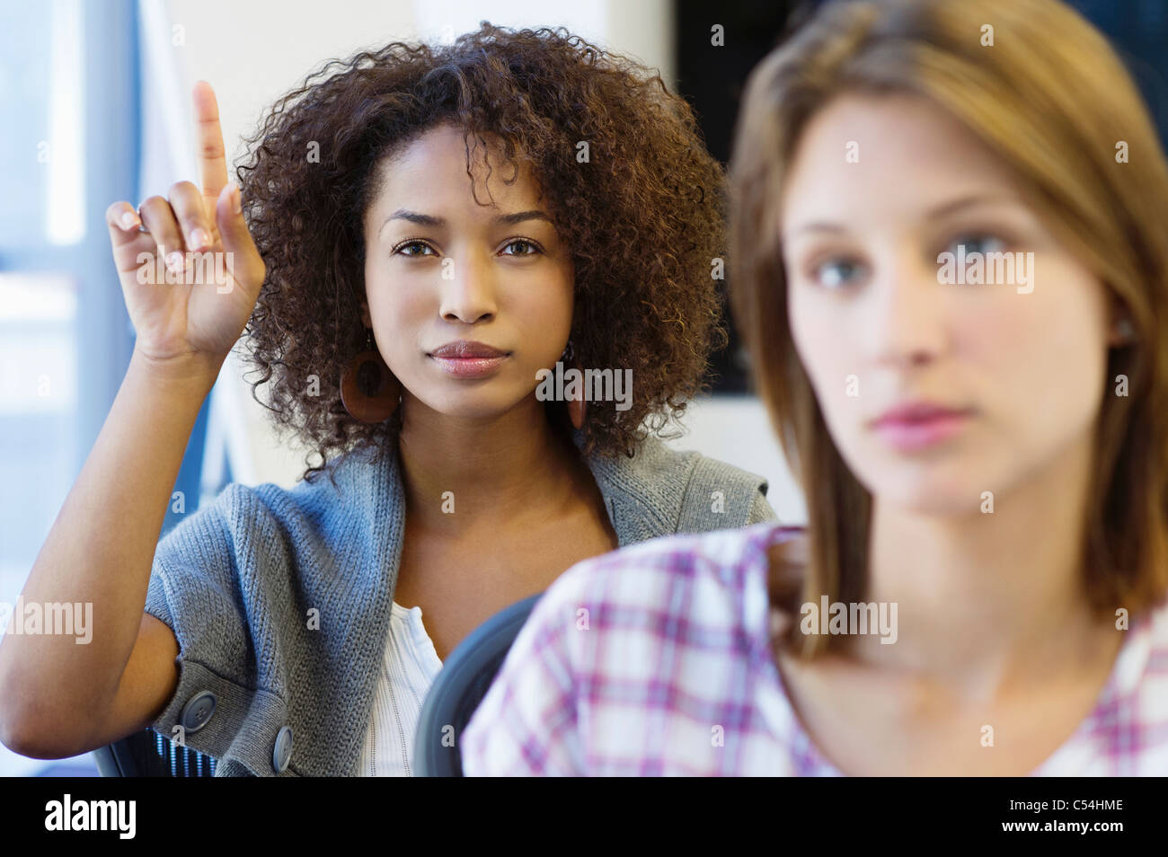 Two women sitting in classroom with focus on African American woman ...