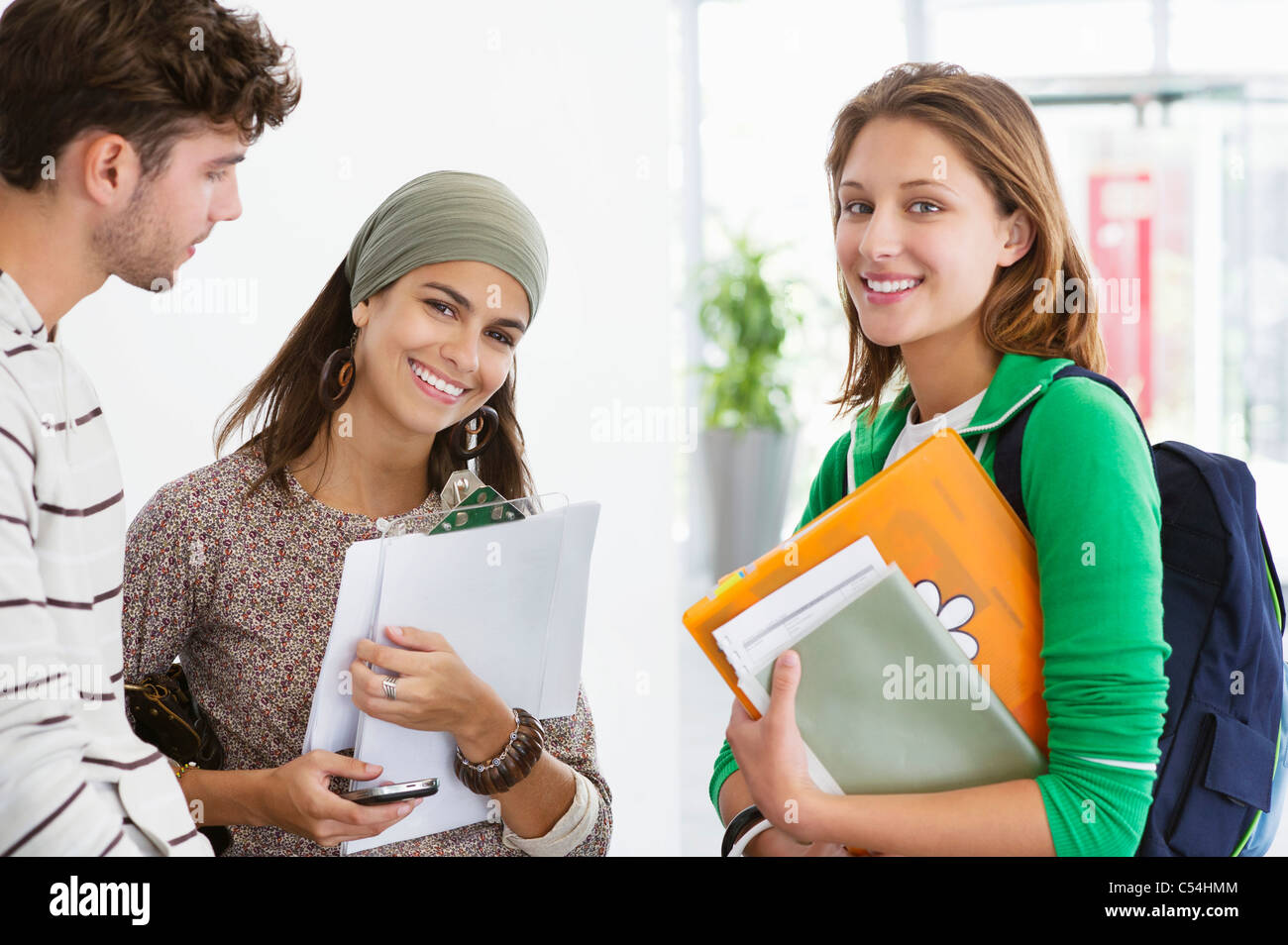 Three university students standing together and smiling Stock Photo - Alamy