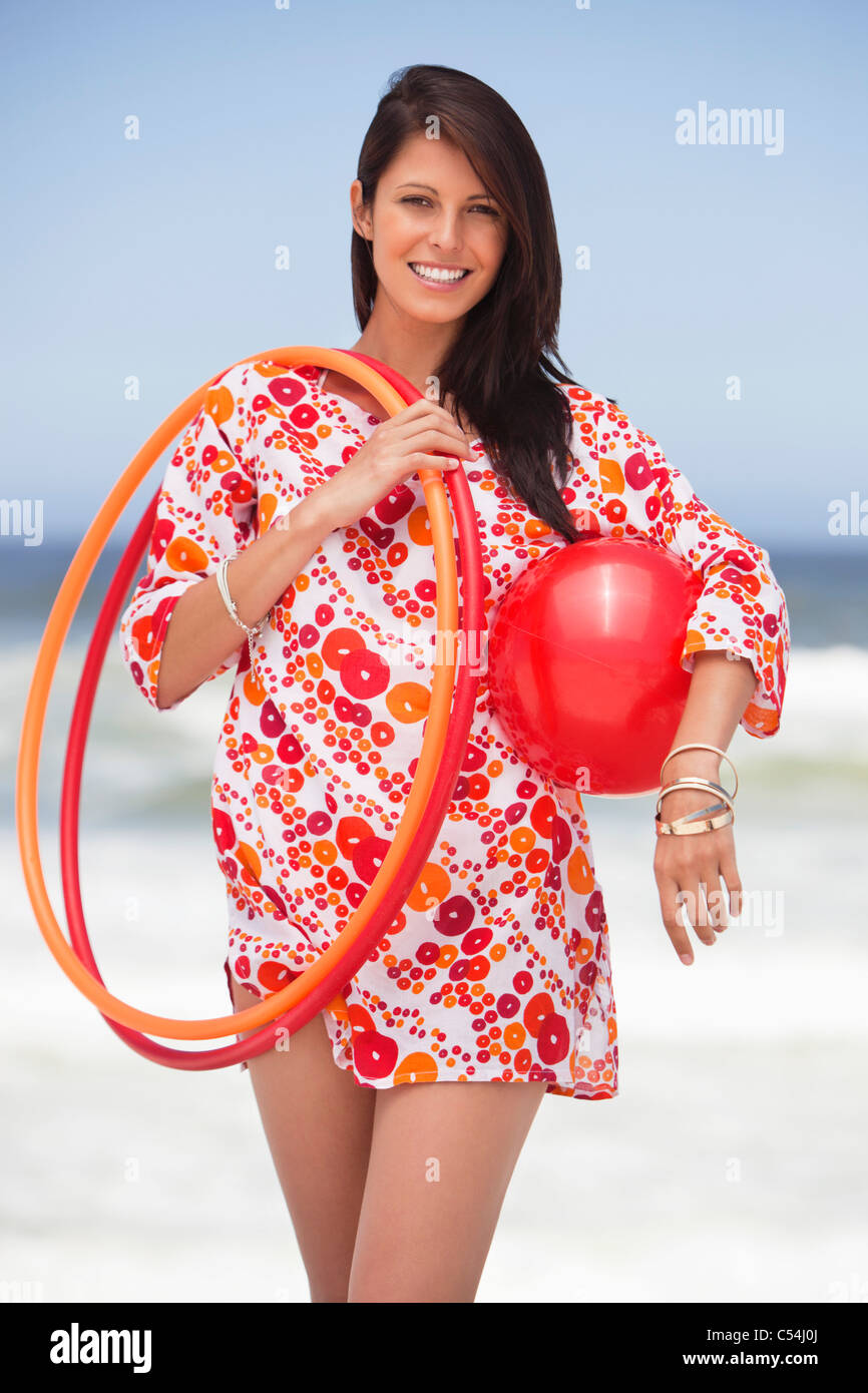Portrait of a young woman carrying ball and plastic hoops Stock Photo ...