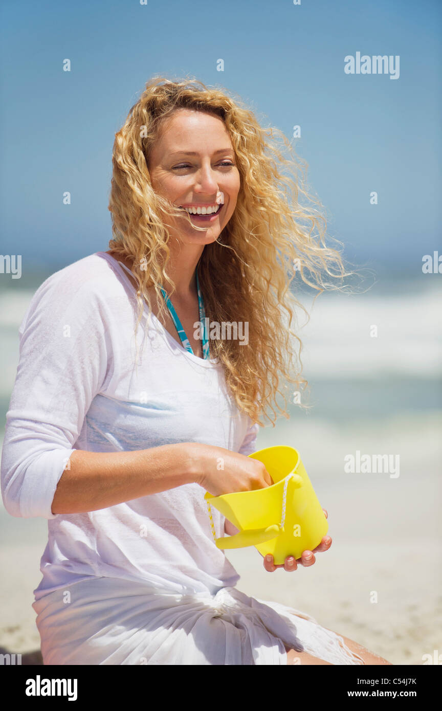 Beautiful woman holding plastic bucket on the beach Stock Photo - Alamy