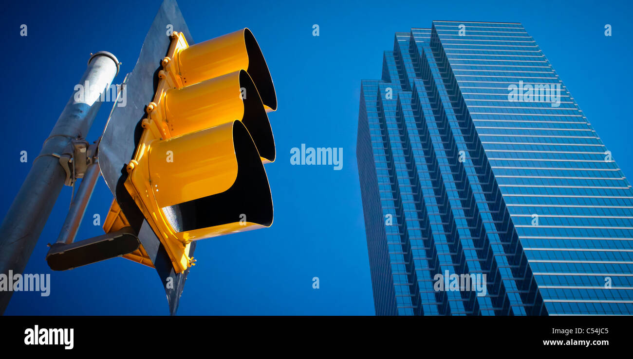 Yellow traffic light with tall office building in the background Stock ...
