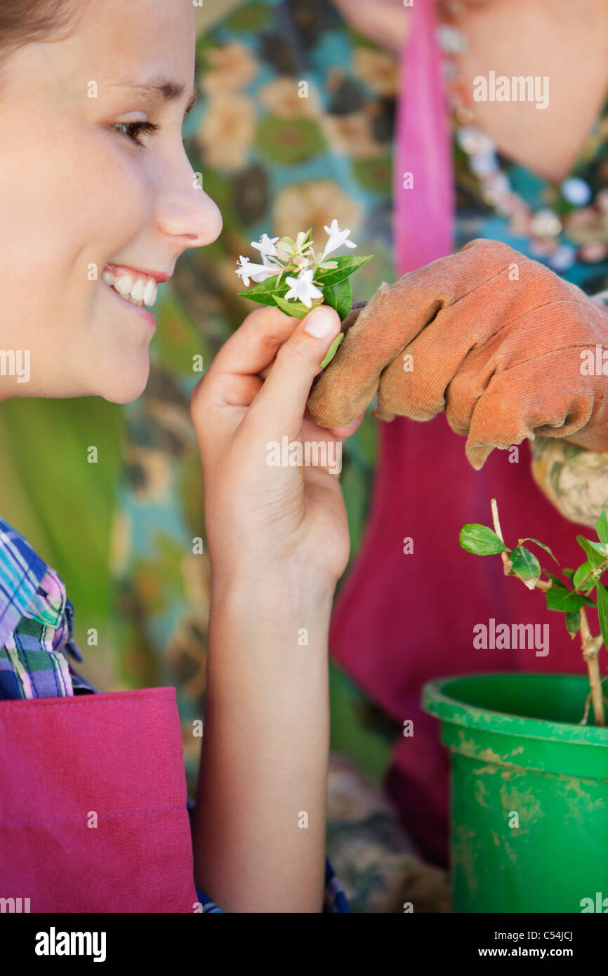 Girl smelling a flower in a garden Stock Photo - Alamy