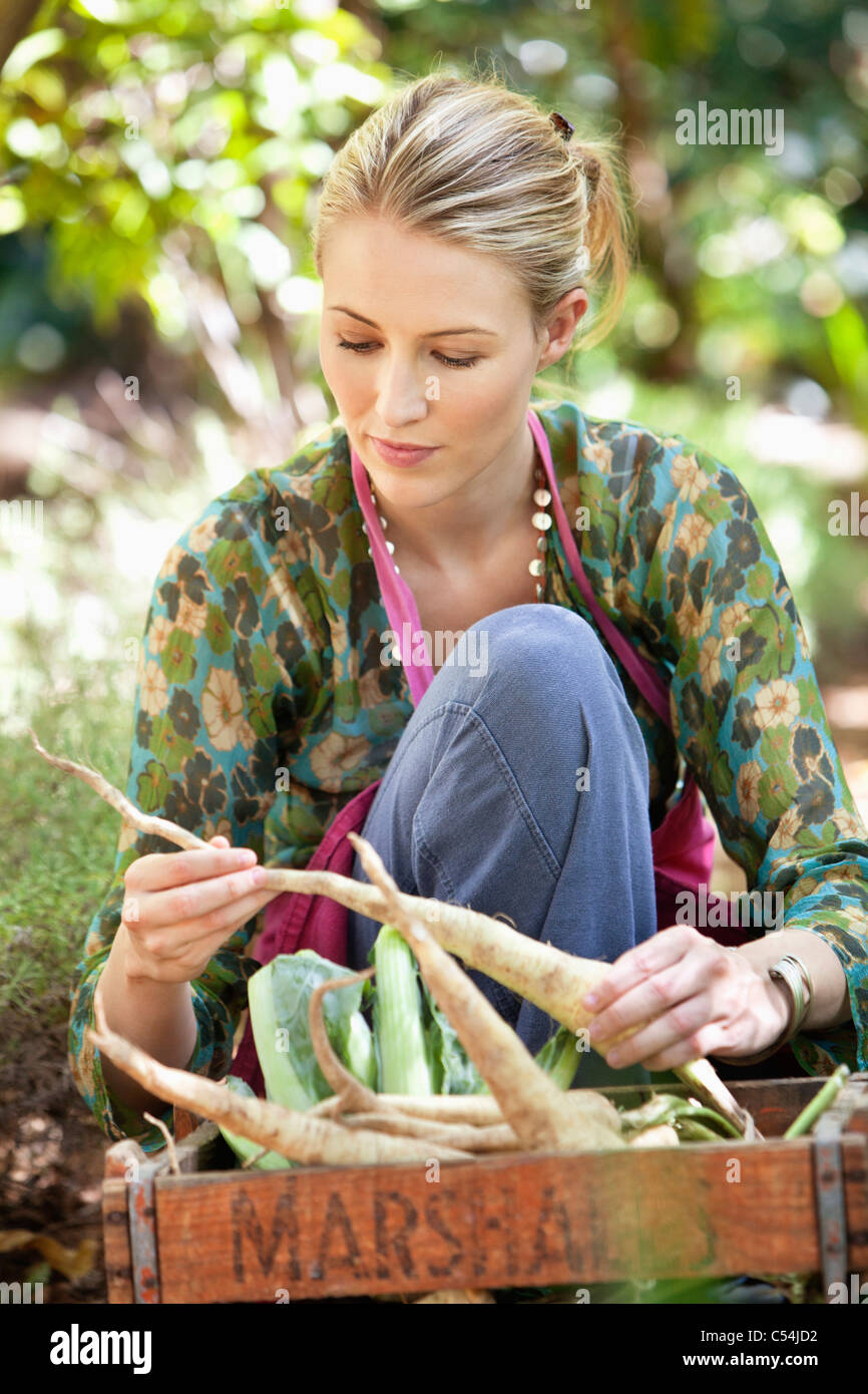 Woman sitting near a crate of radish Stock Photo - Alamy