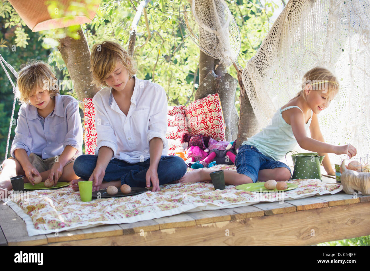 Children eating food in tree house Stock Photo - Alamy
