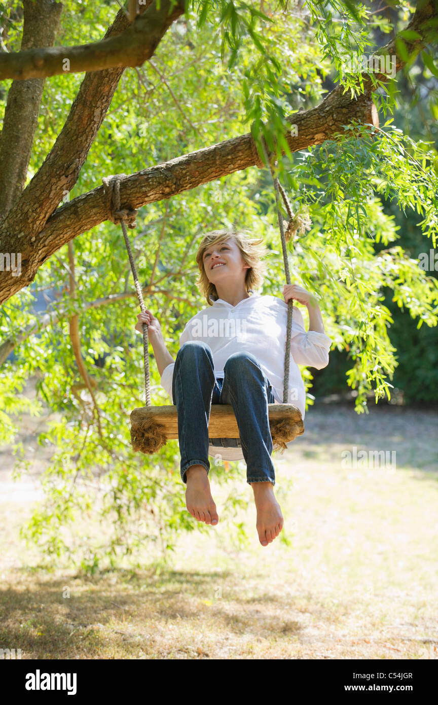 Happy little boy swinging on tree Stock Photo - Alamy