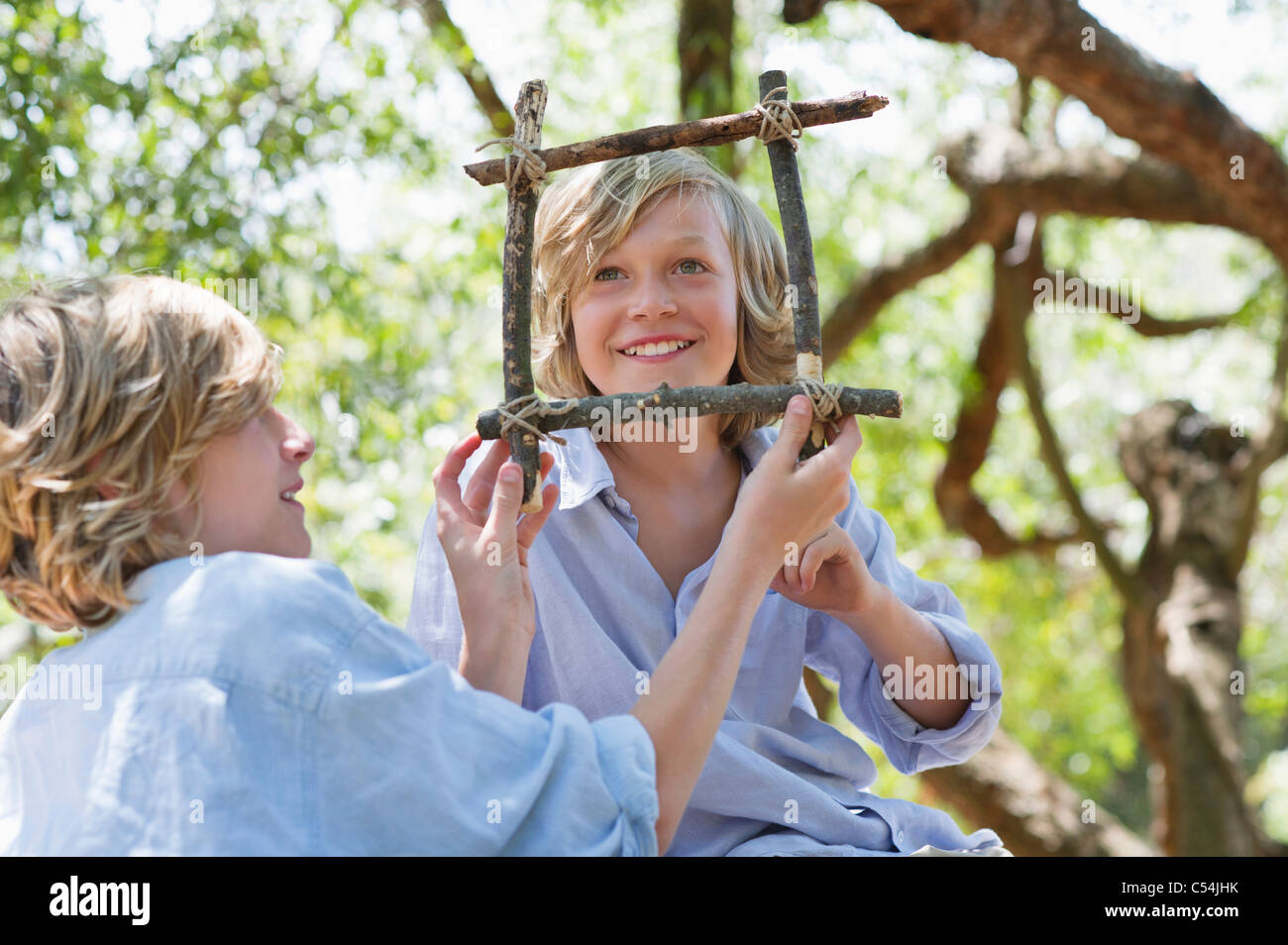 Children making frame of driftwood outdoors Stock Photo - Alamy