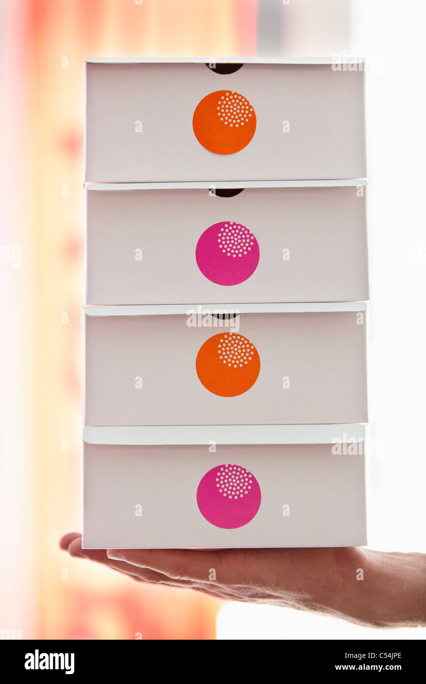 Human hand holding cake boxes in a restaurant Stock Photo - Alamy