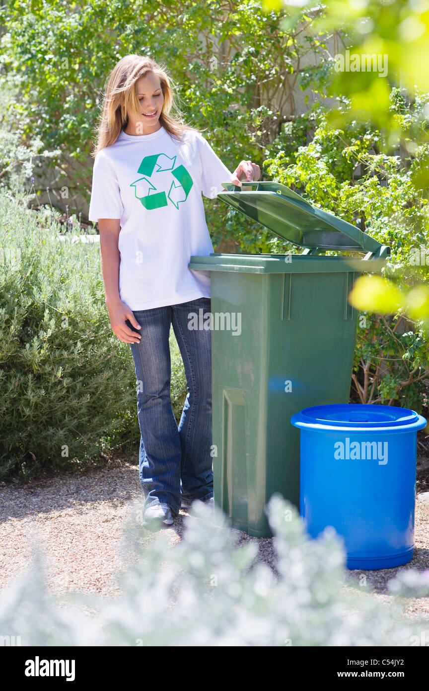 Woman looking into recycling bin Stock Photo - Alamy