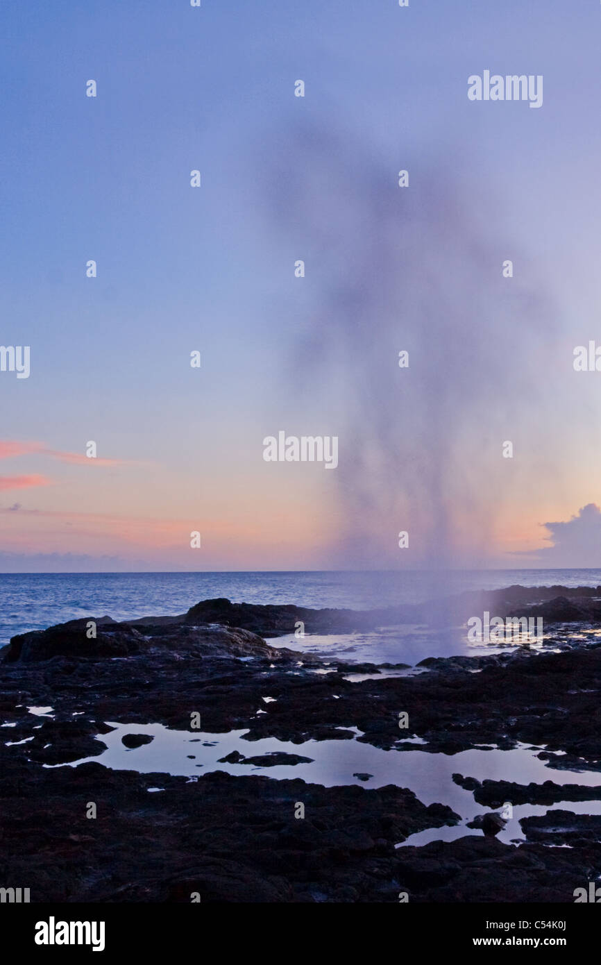Pacific Ocean waves crash under a lava shelf and through a blowhole ...