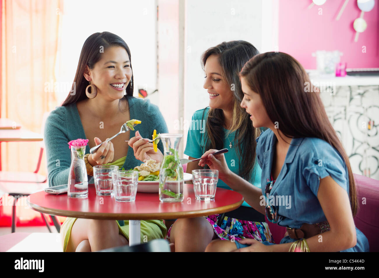 Three women eating food in a restaurant Stock Photo - Alamy
