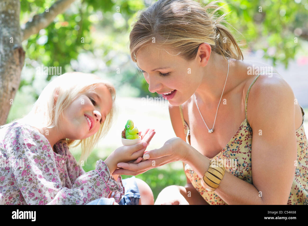Little girl and her mother looking at toy outdoors Stock Photo - Alamy